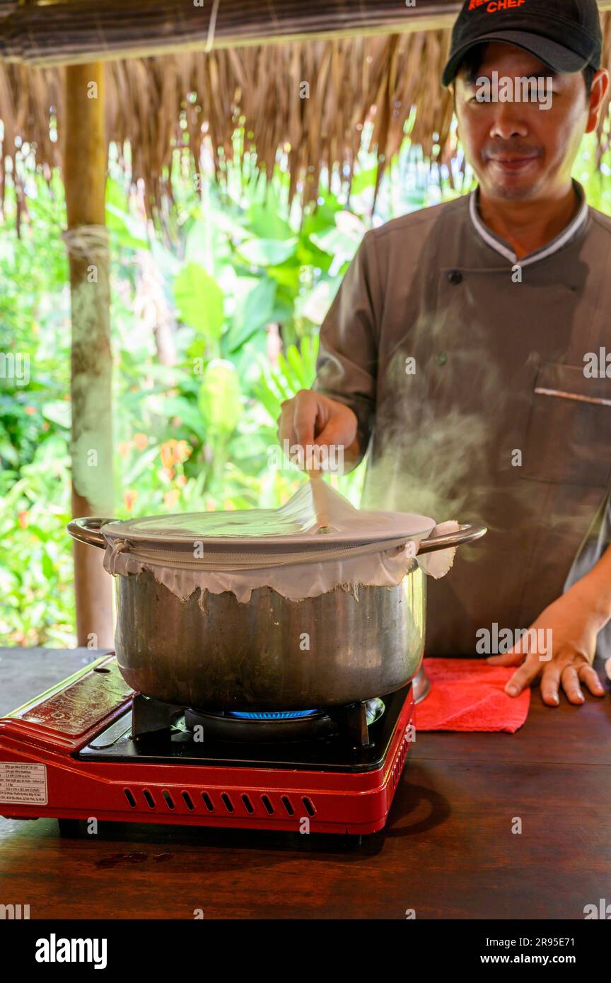 Chef and tutor demonstrates how to cook rice paper used for rolls and ...