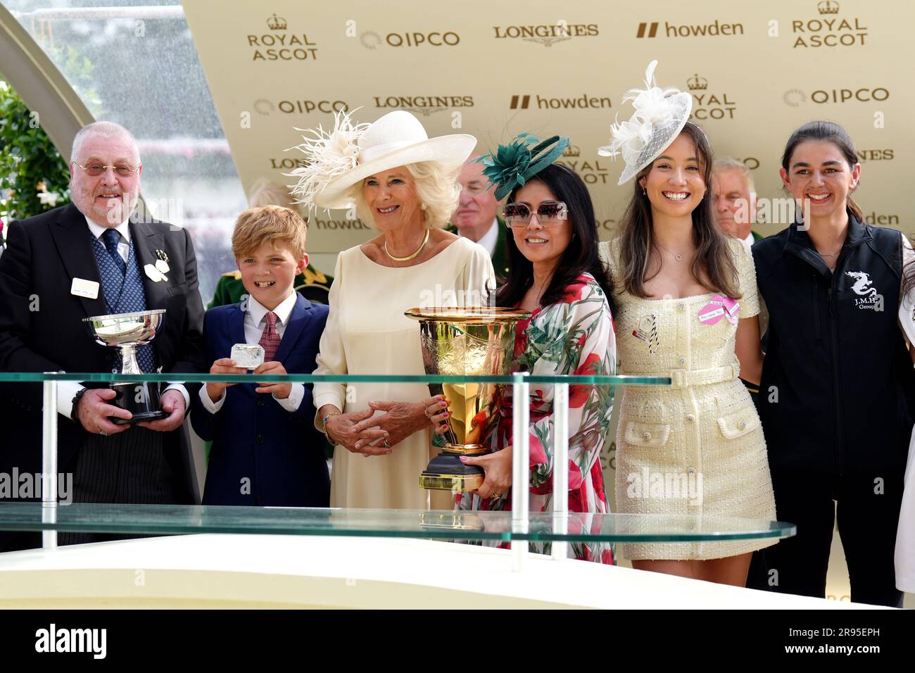 Owner Fitri Hay (centre right) is presented the trophy by Queen Camilla ...