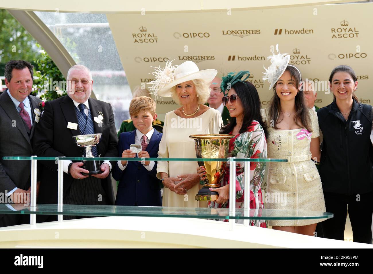 Owner Fitri Hay (centre right) is presented the trophy by Queen Camilla ...