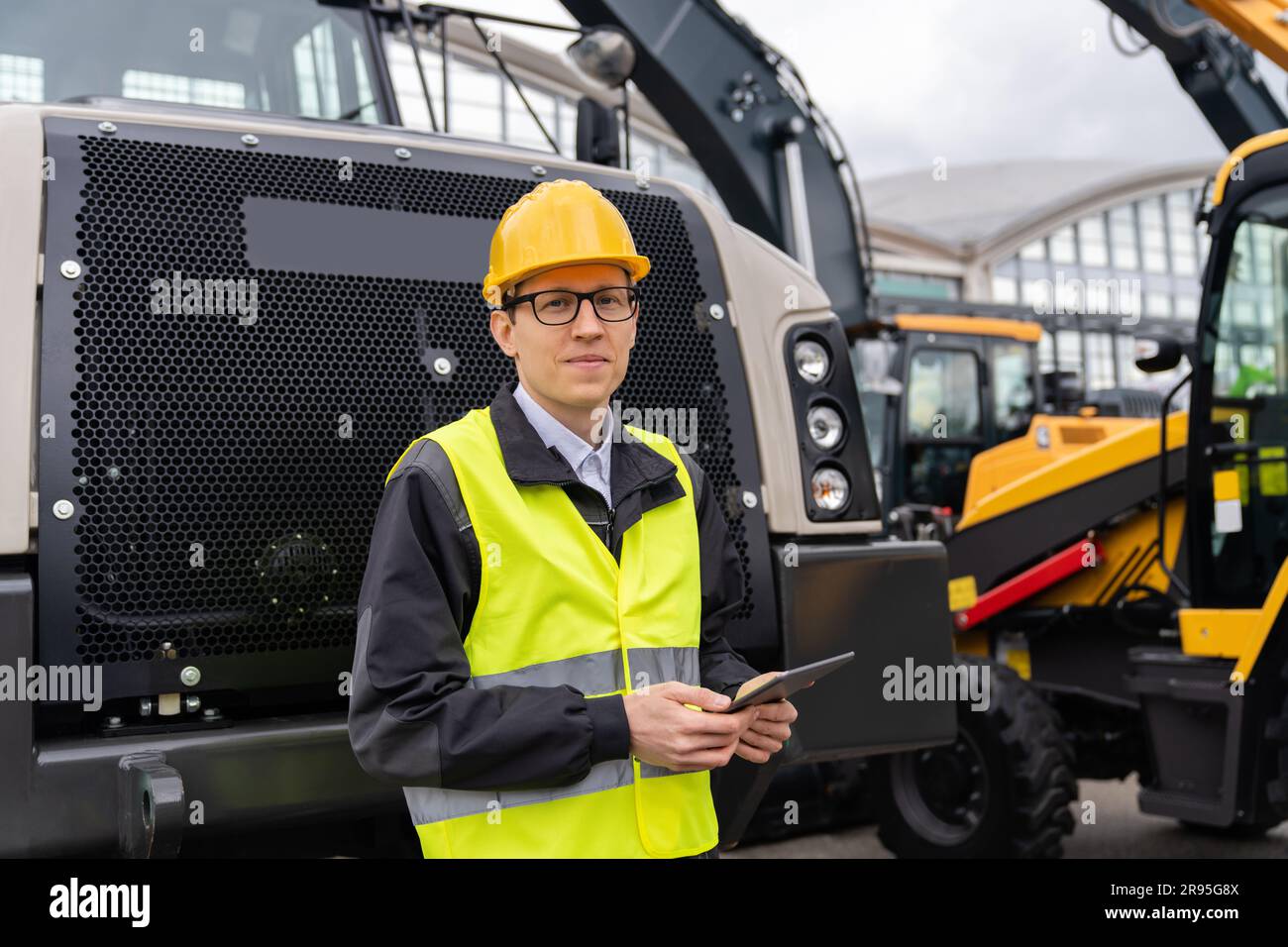 Engineer with tablet computer stands next to mining truck Stock Photo ...