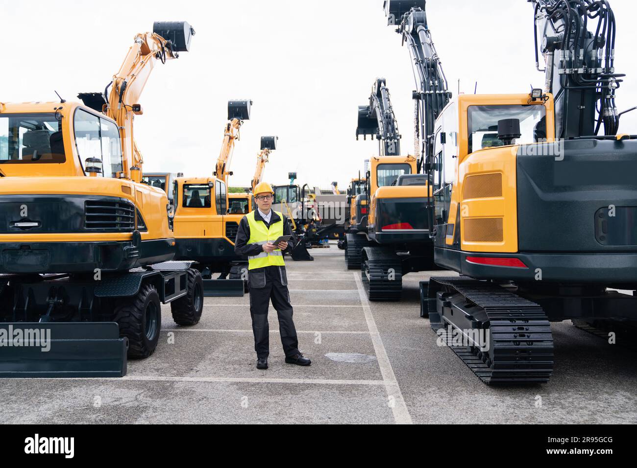 Engineer in a helmet with a digital tablet stands next to construction ...