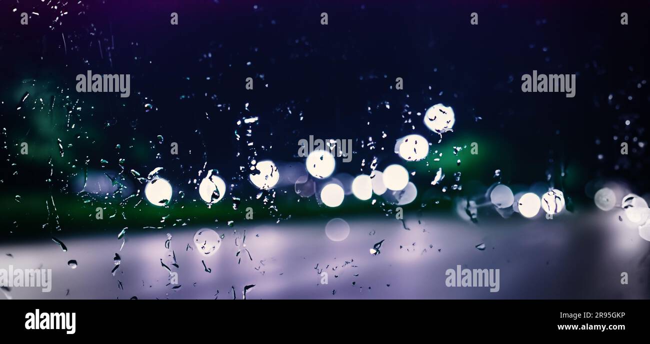 Rain shower on car windshield or car window and blurry road in ...
