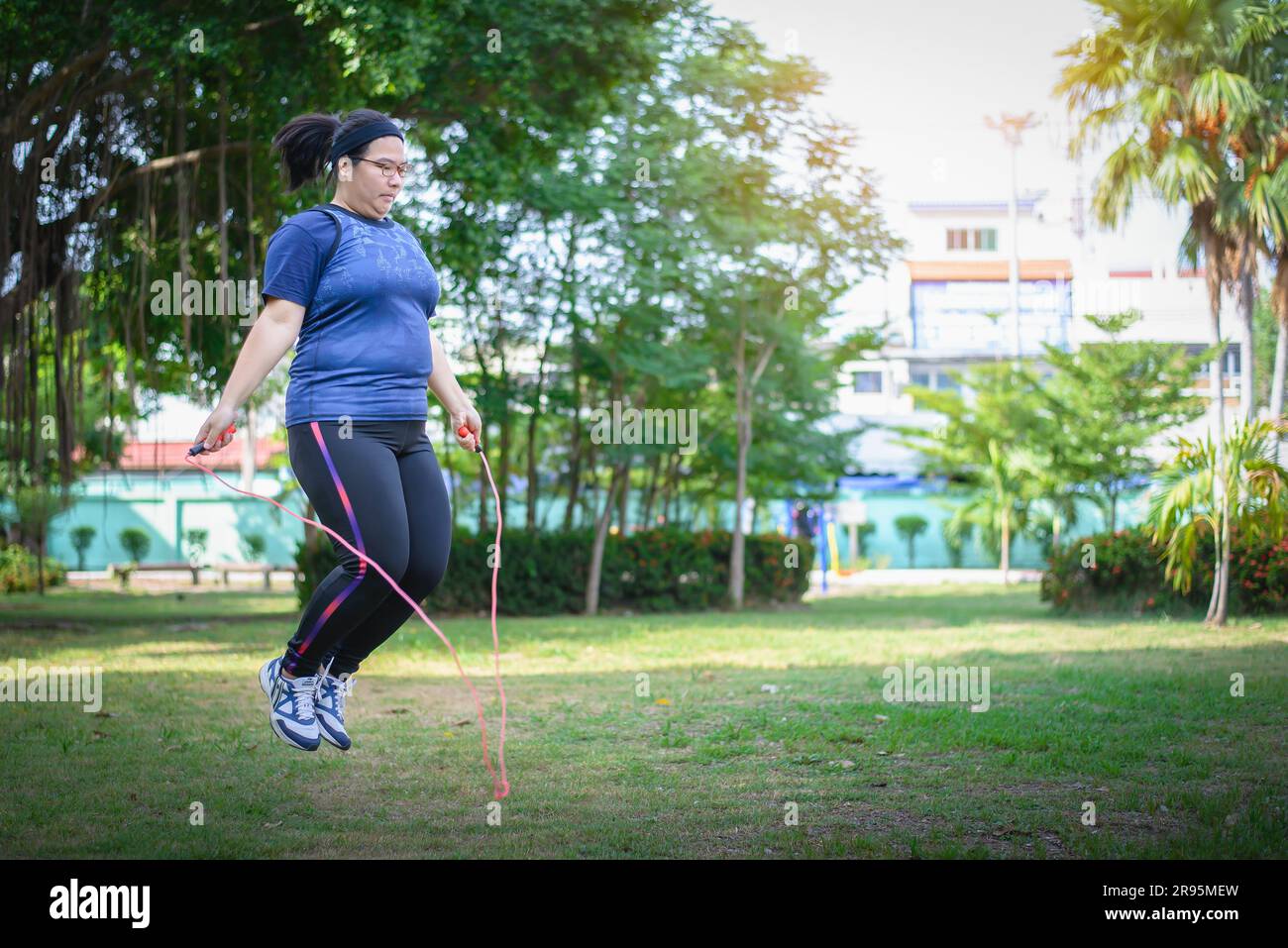 asian fat woman jumping rope in the park Stock Photo - Alamy