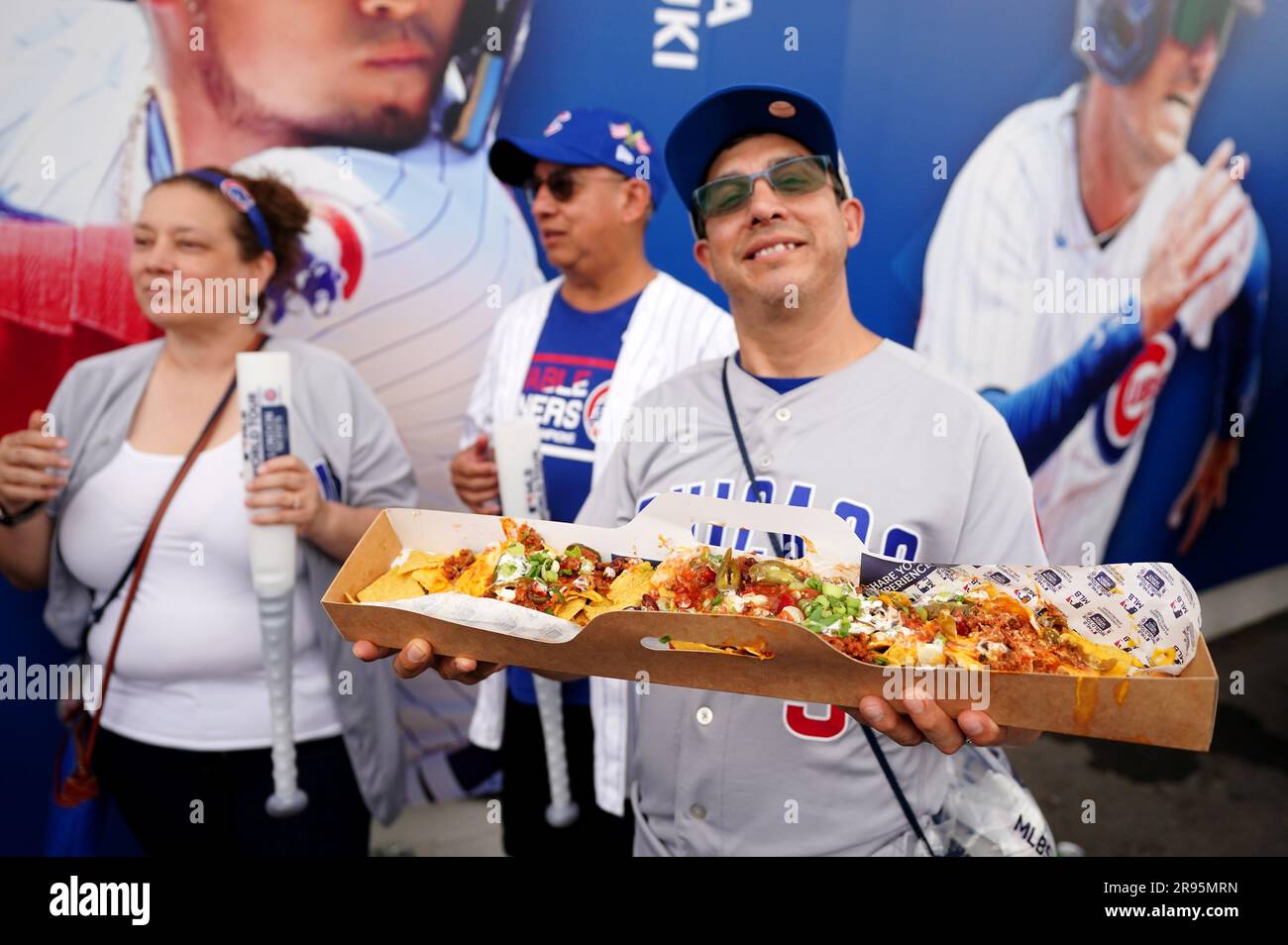 A fan poses with an ultra-long carrier of nachos ahead of the MLB ...