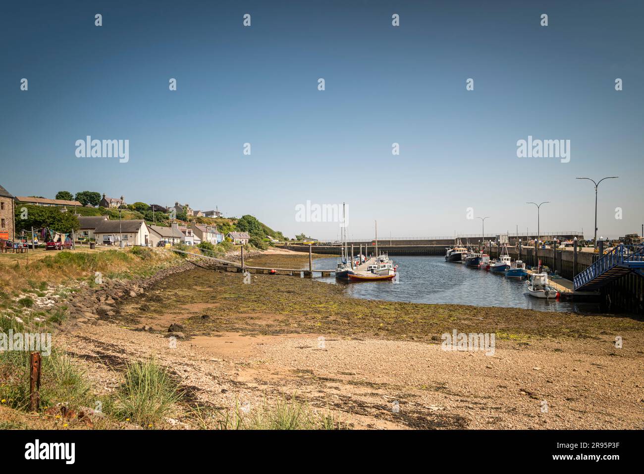 A warm, summer HDR image of boats tied up alongside in the harbour and ...