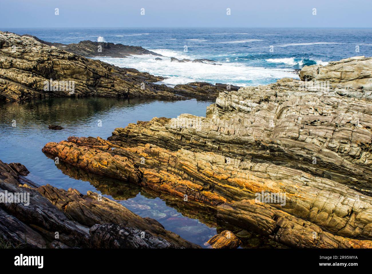 Calm rock pool, sheltered between the rugged rocks of the Tsitsikamma ...