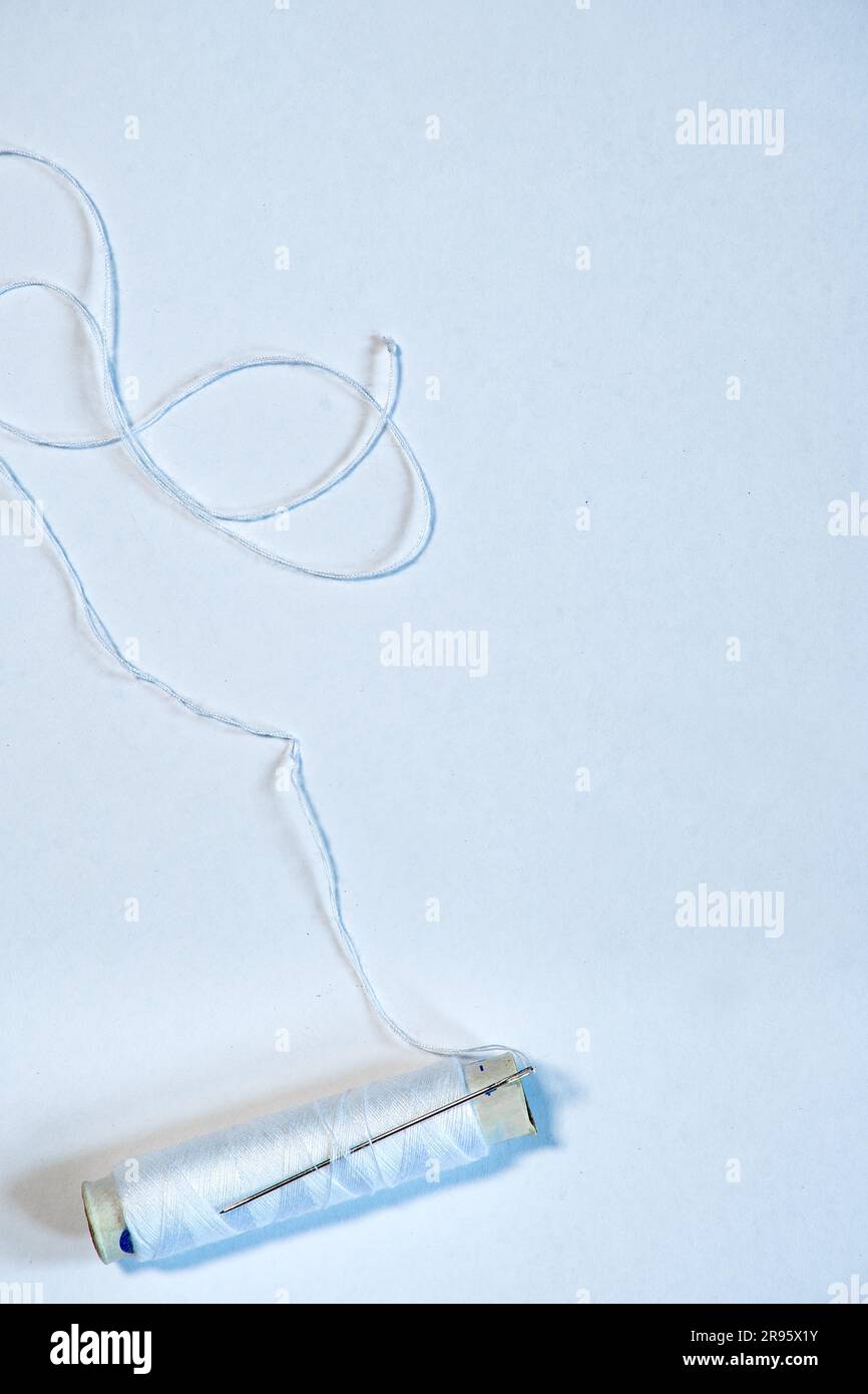 Close-up of a white color thread spool of the sewing machine with a ...