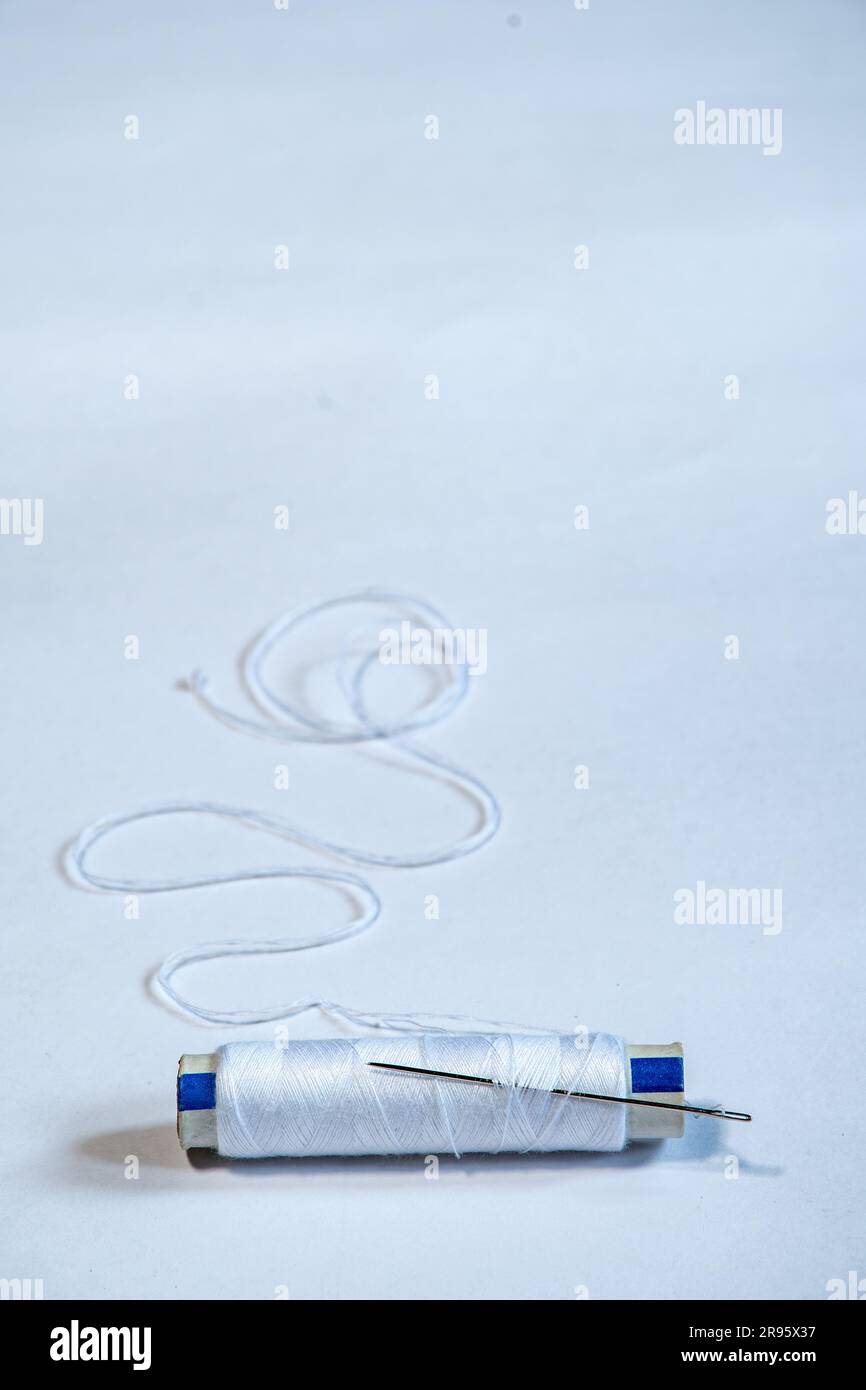 Close-up of a white color thread spool of the sewing machine with a ...