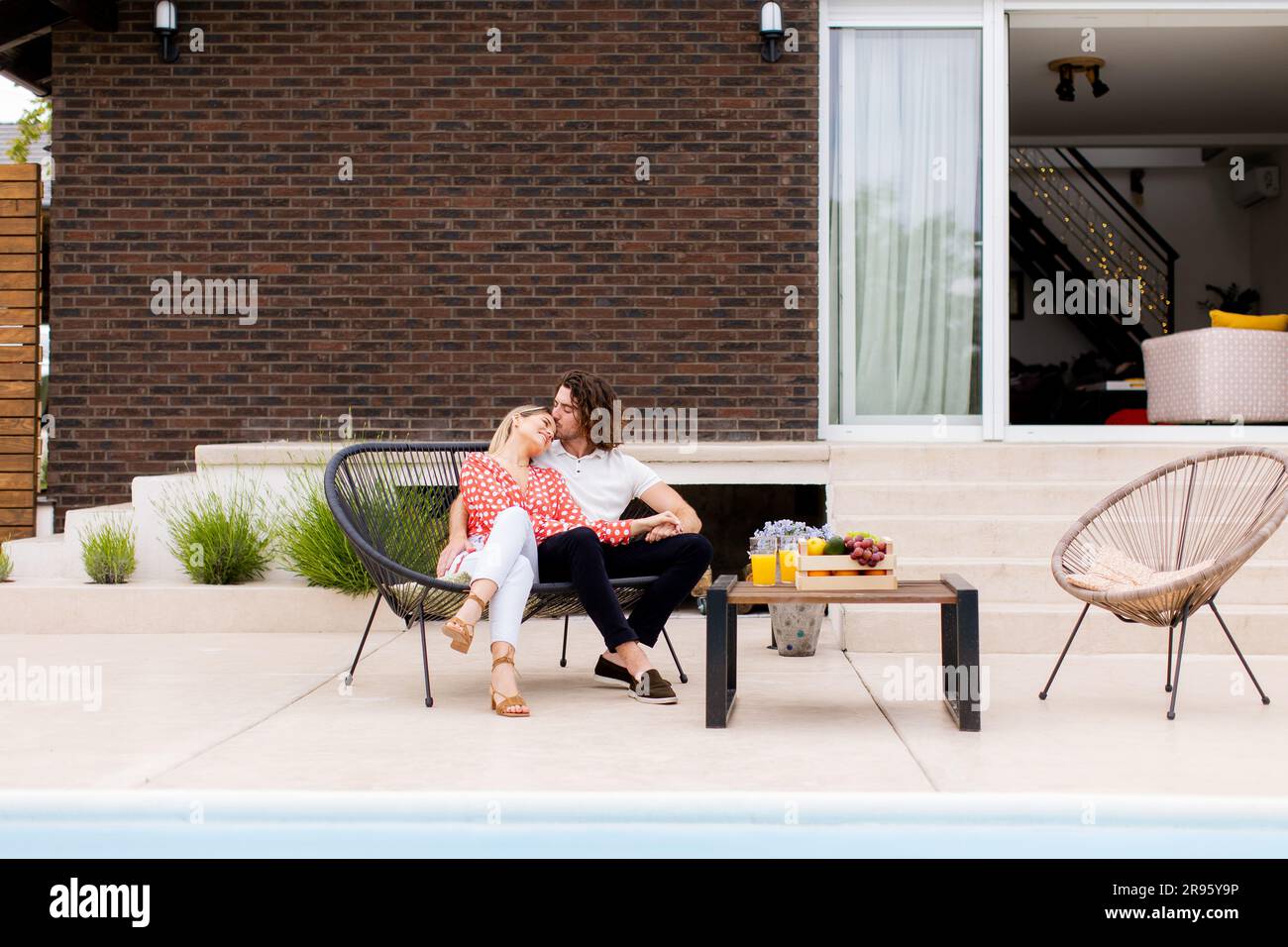 Handsome young couple relaxing by the swimming pool in the house backyard Stock Photo - Alamy