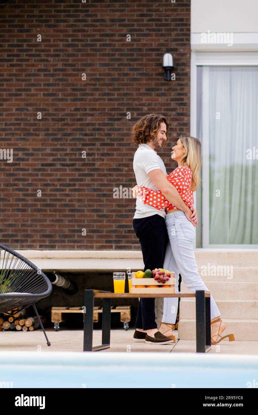 Handsome young couple relaxing by the swimming pool in the house backyard Stock Photo - Alamy