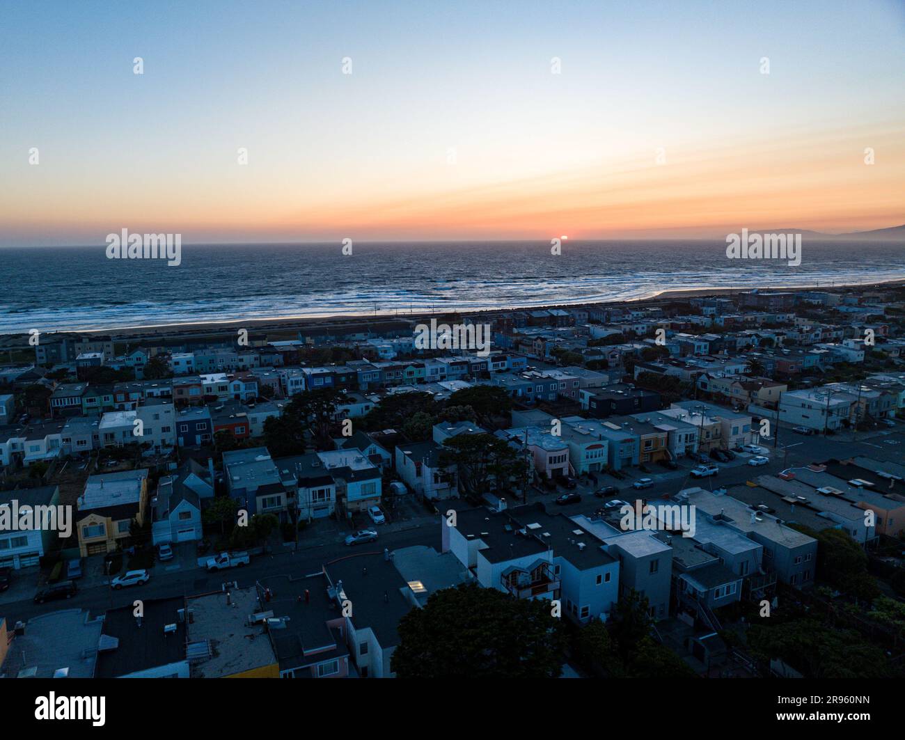 An aerial view of a neighborhood illuminated by the setting sun. San ...
