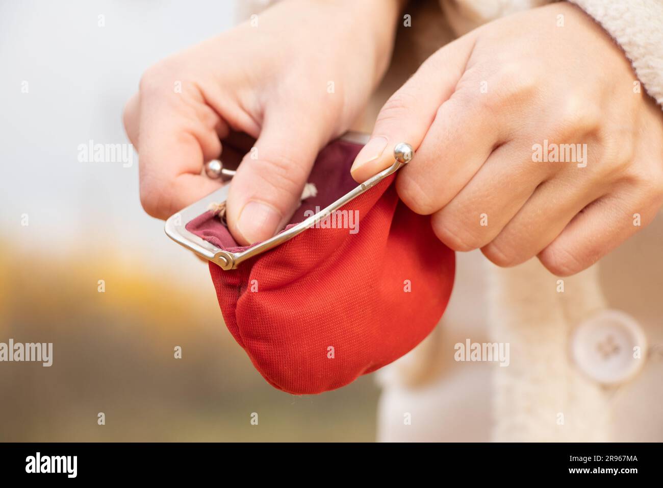 red empty wallet in the hands of a girl on the street, lack of money ...