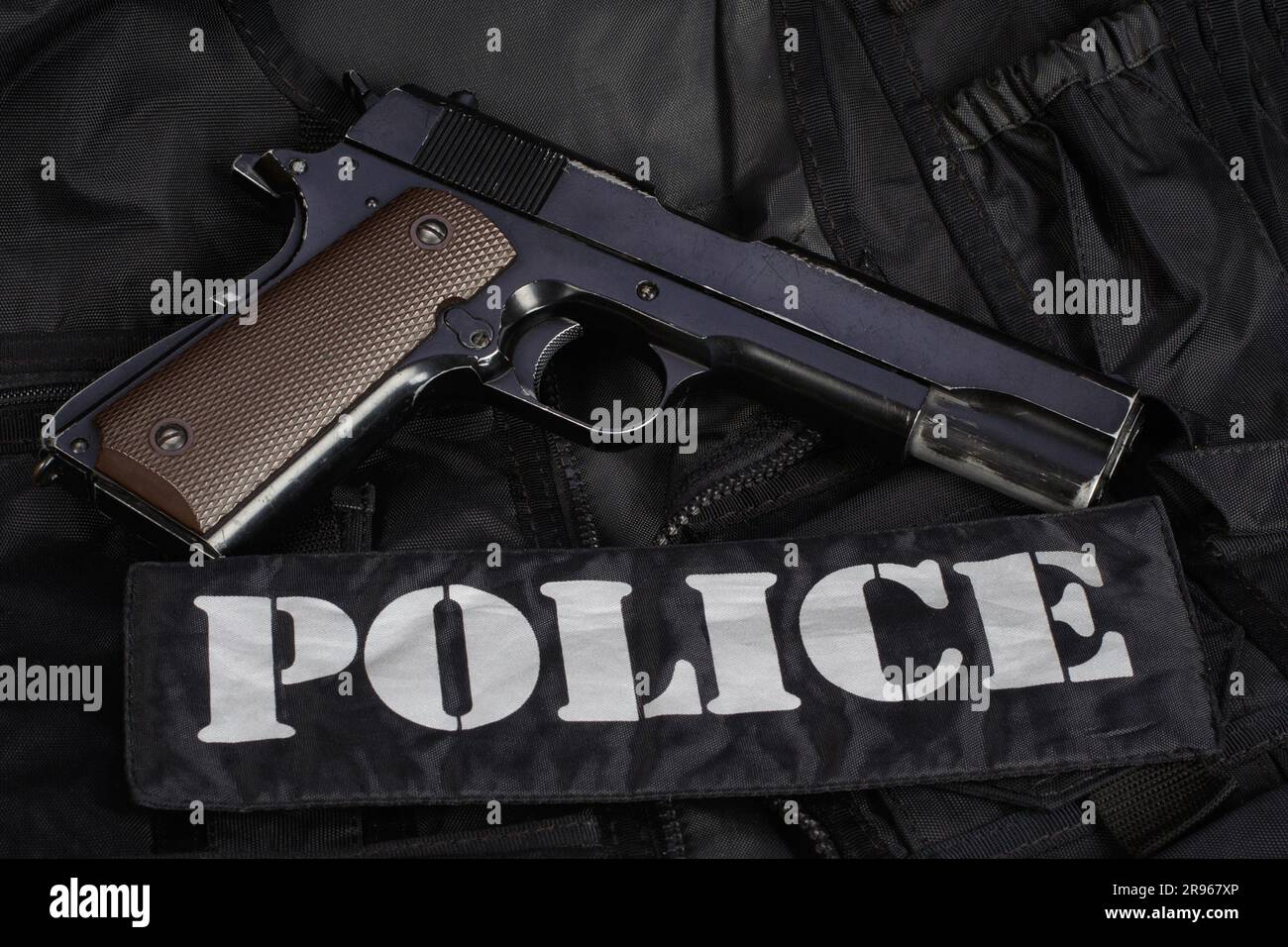 Police handgun on black uniform background Stock Photo - Alamy