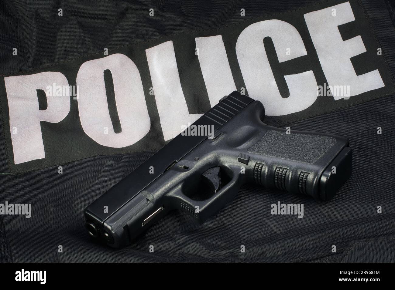 Police hand gun on black uniform background Stock Photo - Alamy