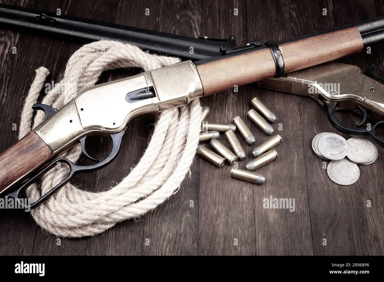 Old west guns. Lever-action repeating rifles with ammunition on wooden ...