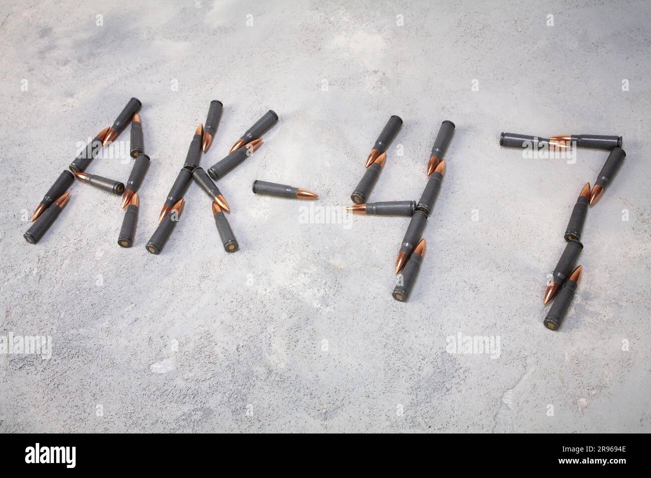 kalashnikov ak 47 word from 7,62 mm bullets on grey concrete surface ...