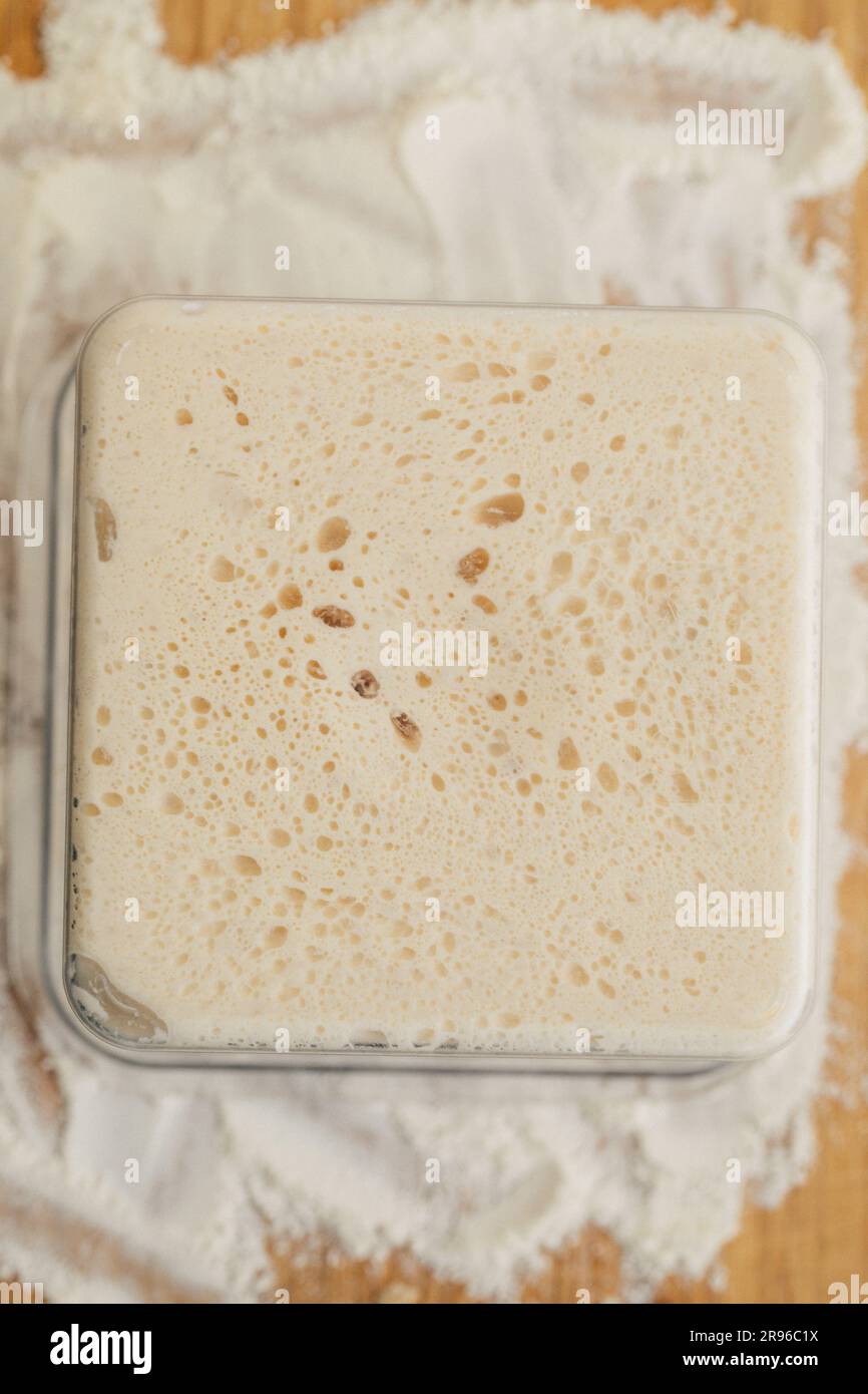 directly above view of making sourdough bread, turning out dough from ...