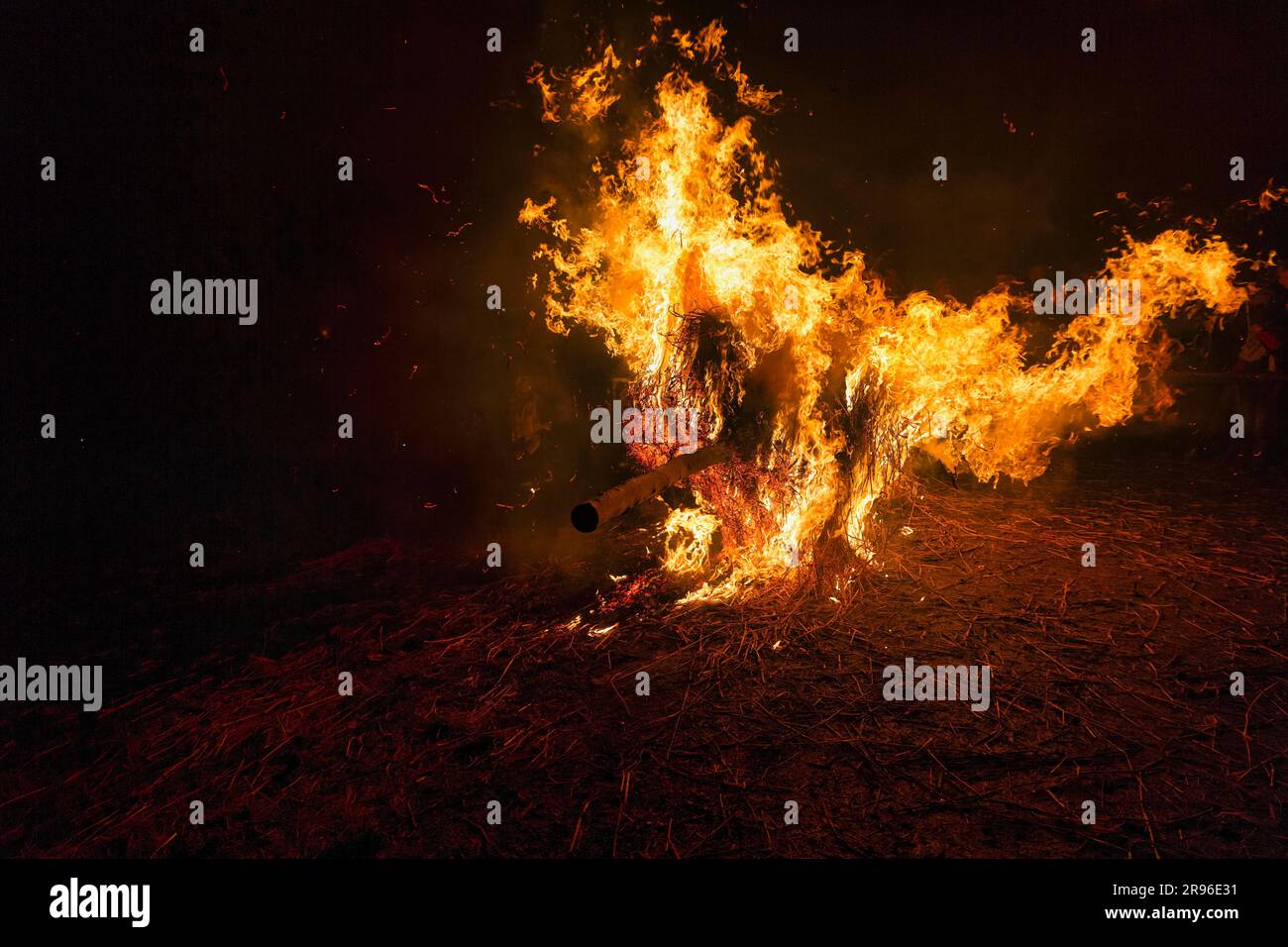 Fire wheel, burning wooden wheel rolls in the night, Easter festival ...