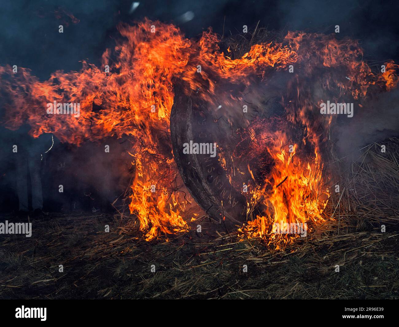 Fire wheel, burning wooden wheel rolls in the night, Easter festival ...