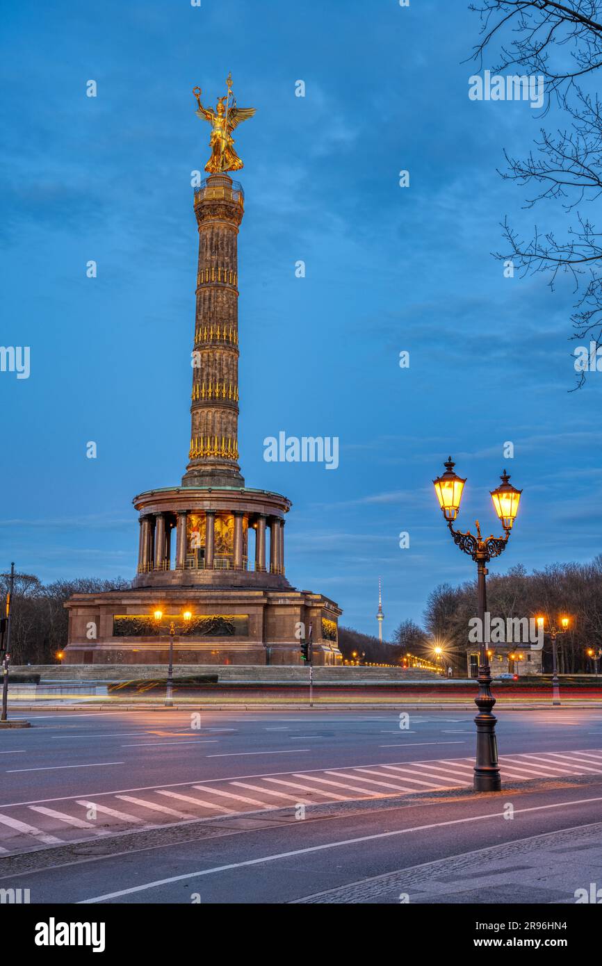 The famous Victory Column with a streetlamp and tree branches in Berlin ...