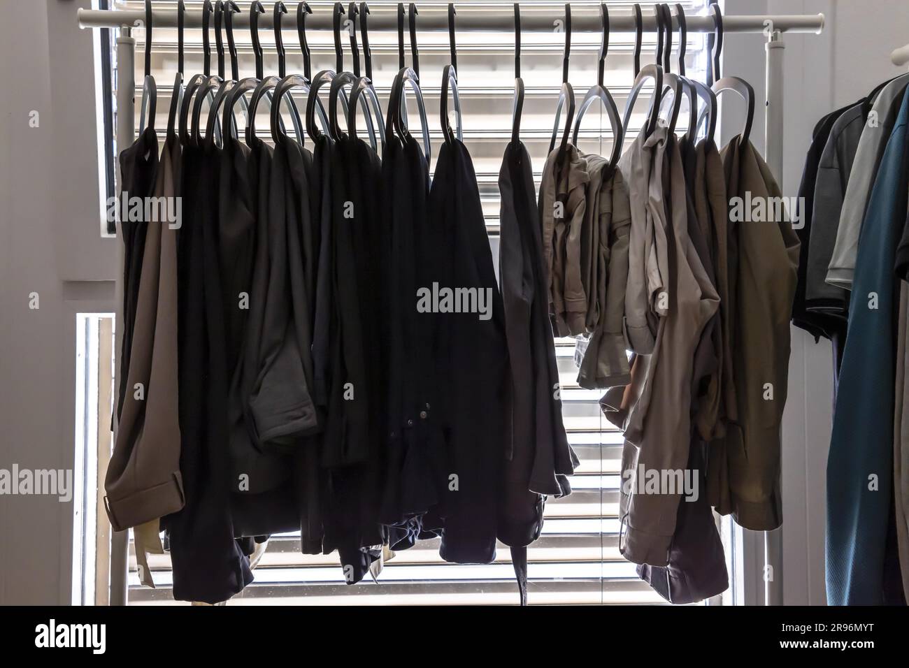 Clothes hanger on rack, window with blinds Stock Photo - Alamy