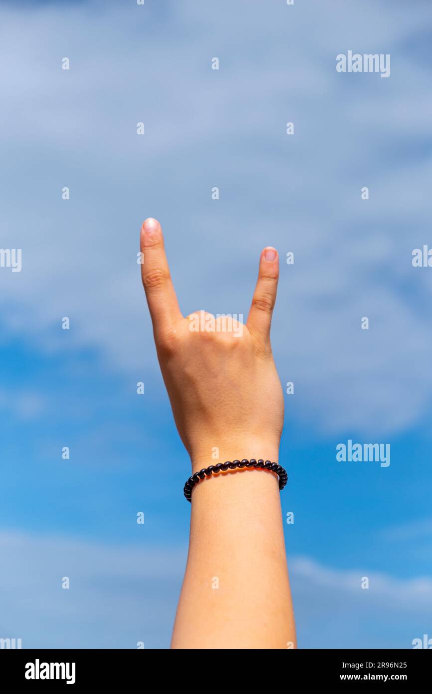 hand of a girl making the sign of horns with her fingers, signs concept ...