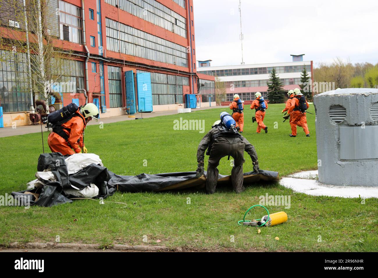 Professional firefighters, rescuers in protective fireproof suits ...
