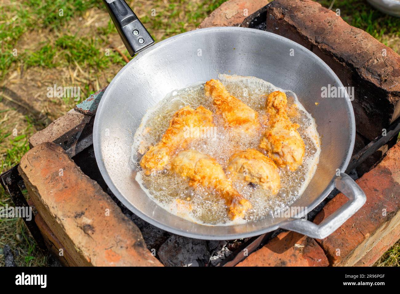 chicken drumstick in batter is fried in oil in a wok in the country ...