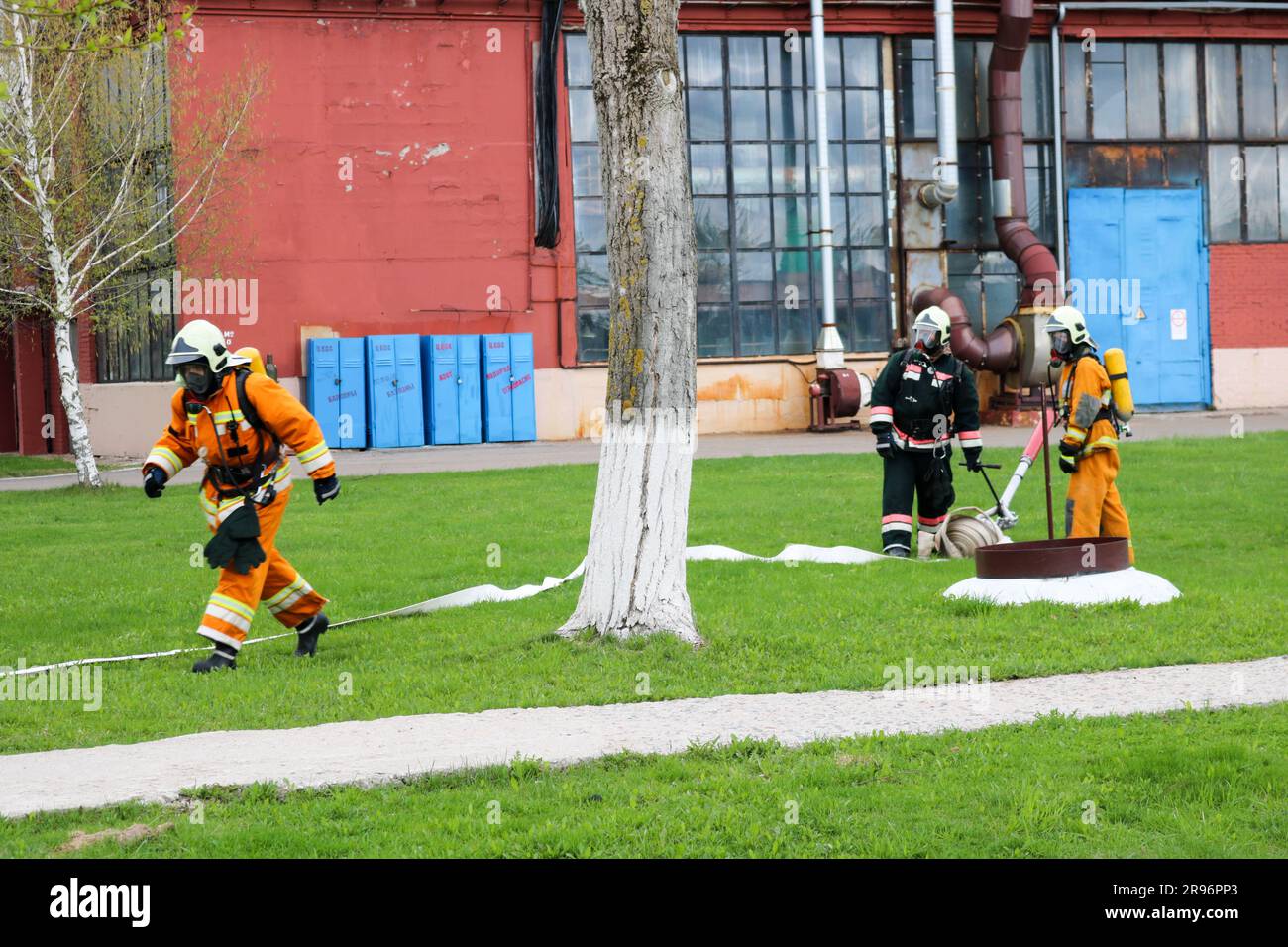 Professional firefighters, rescuers in protective fireproof suits ...