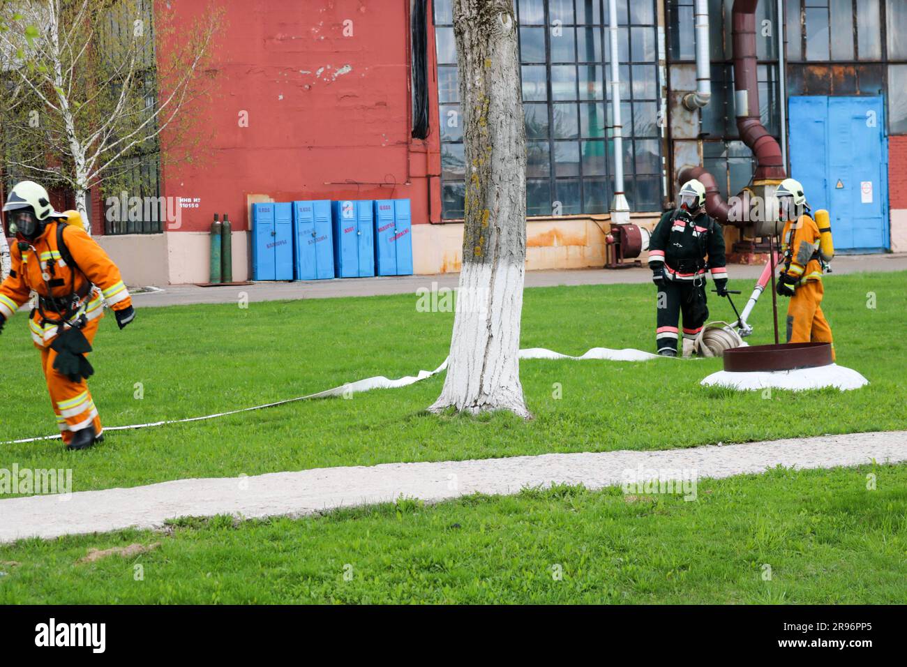 Professional firefighters, rescuers in protective fireproof suits ...
