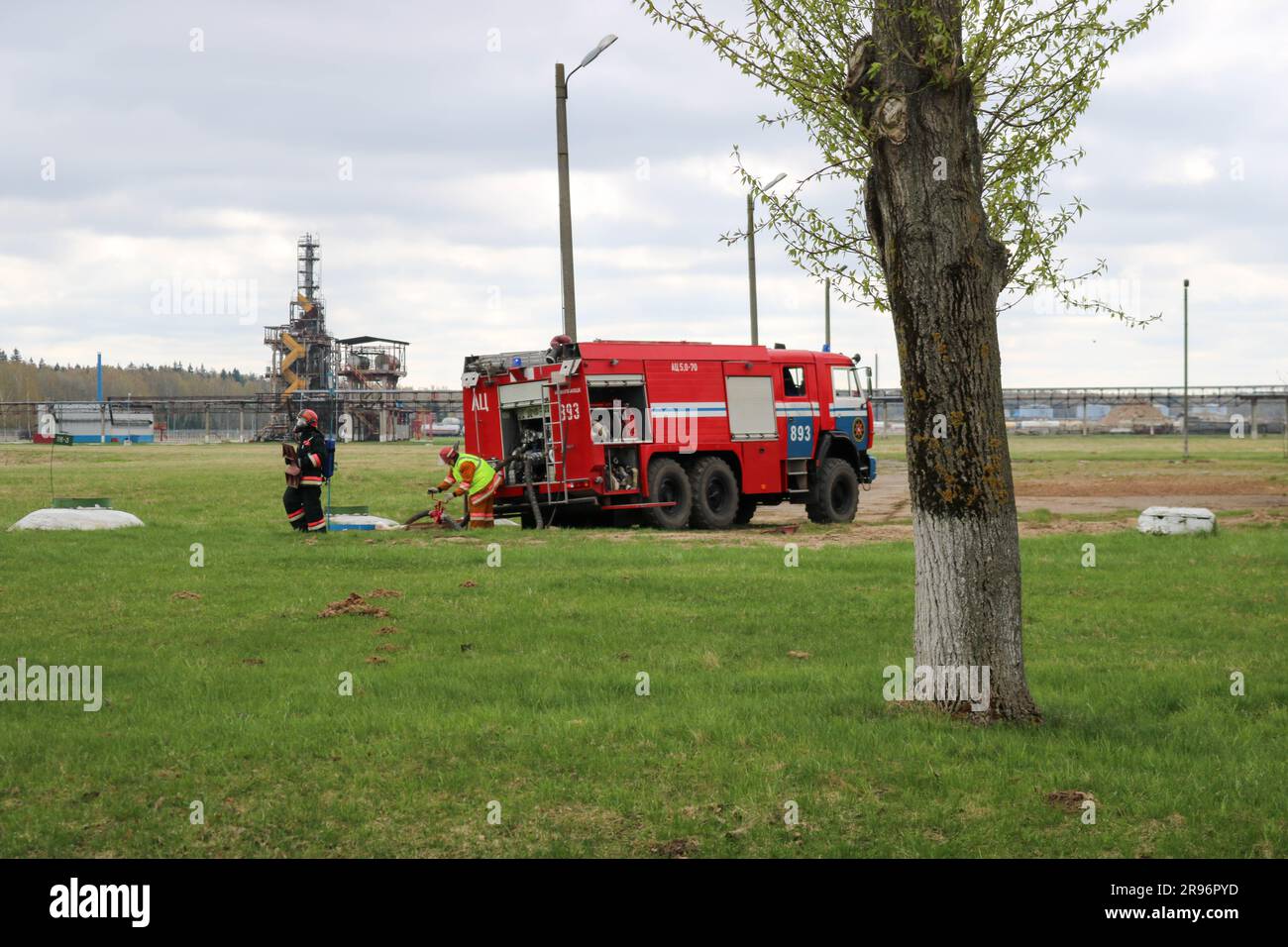A large red fire rescue vehicle, a truck to extinguish a fire and male ...