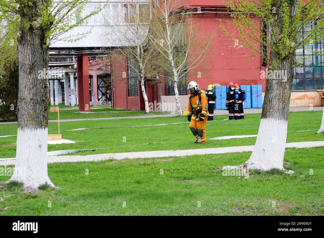 Professional firefighters, rescuers in protective fireproof suits ...