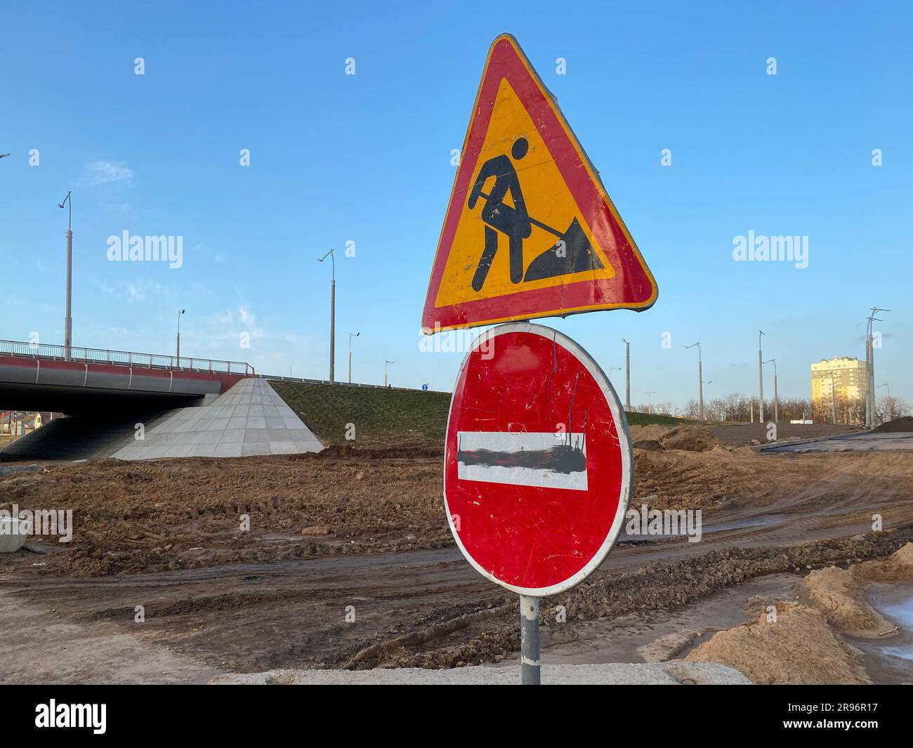 Under construction board sign on the closed road with arrow sign and traffic cone. Caution ...