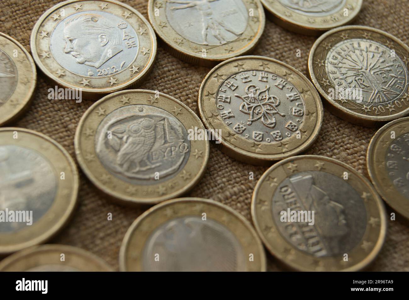One euro coins on natural linen fabric. 1 euro coins of various ...