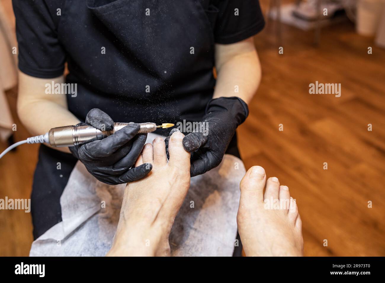 A pedicure master performs a cosmetic procedure for the client's feet ...