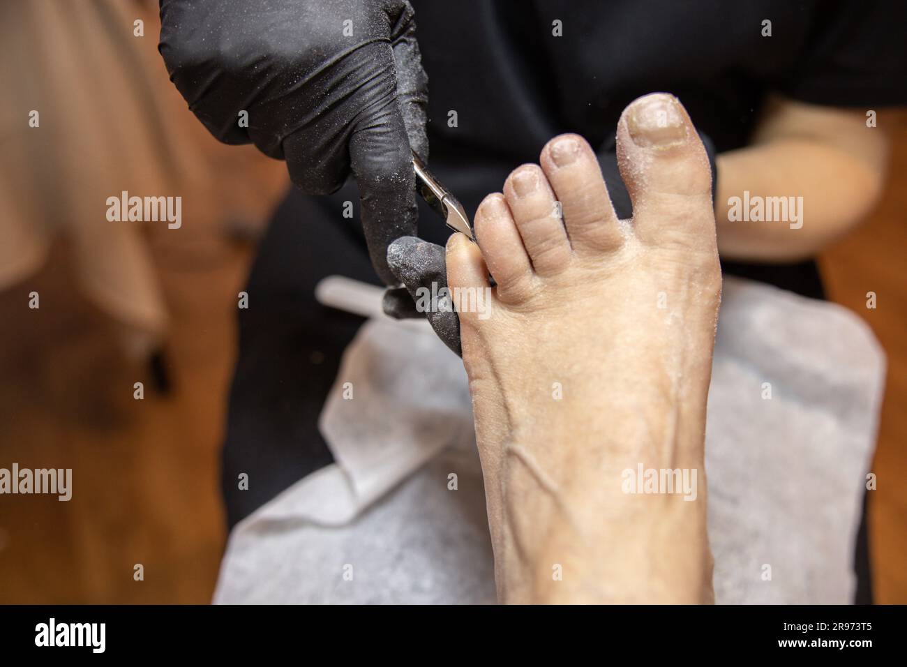 The pedicure master cuts off the nail on the little finger of the ...