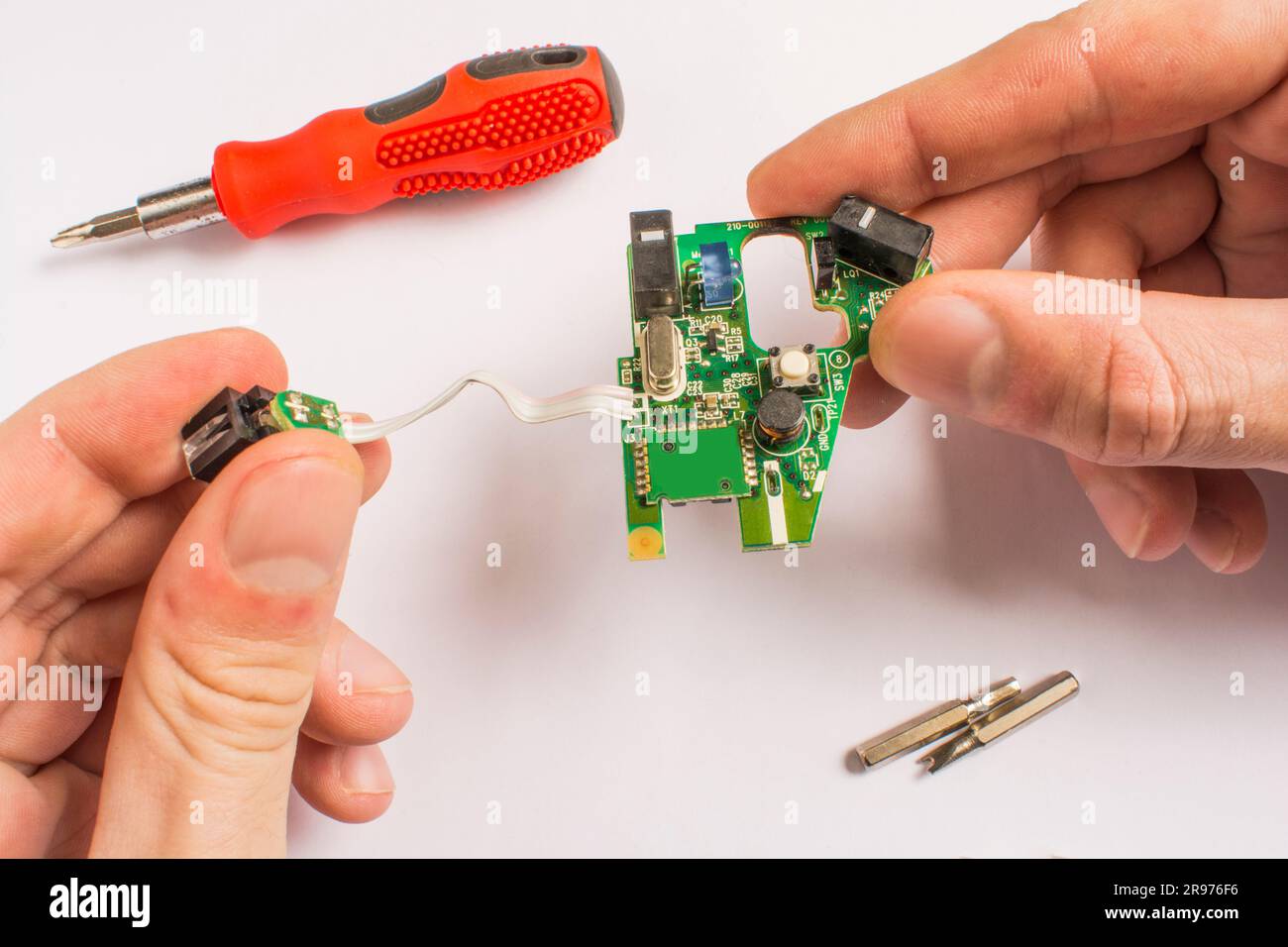 board in hands on a white background with a red screwdriver and ...