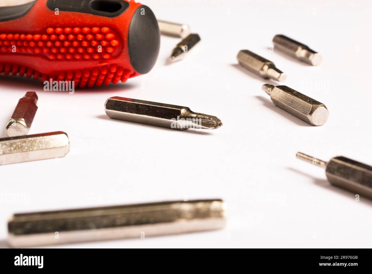 red screwdriver, white background and bits, spare parts Stock Photo - Alamy