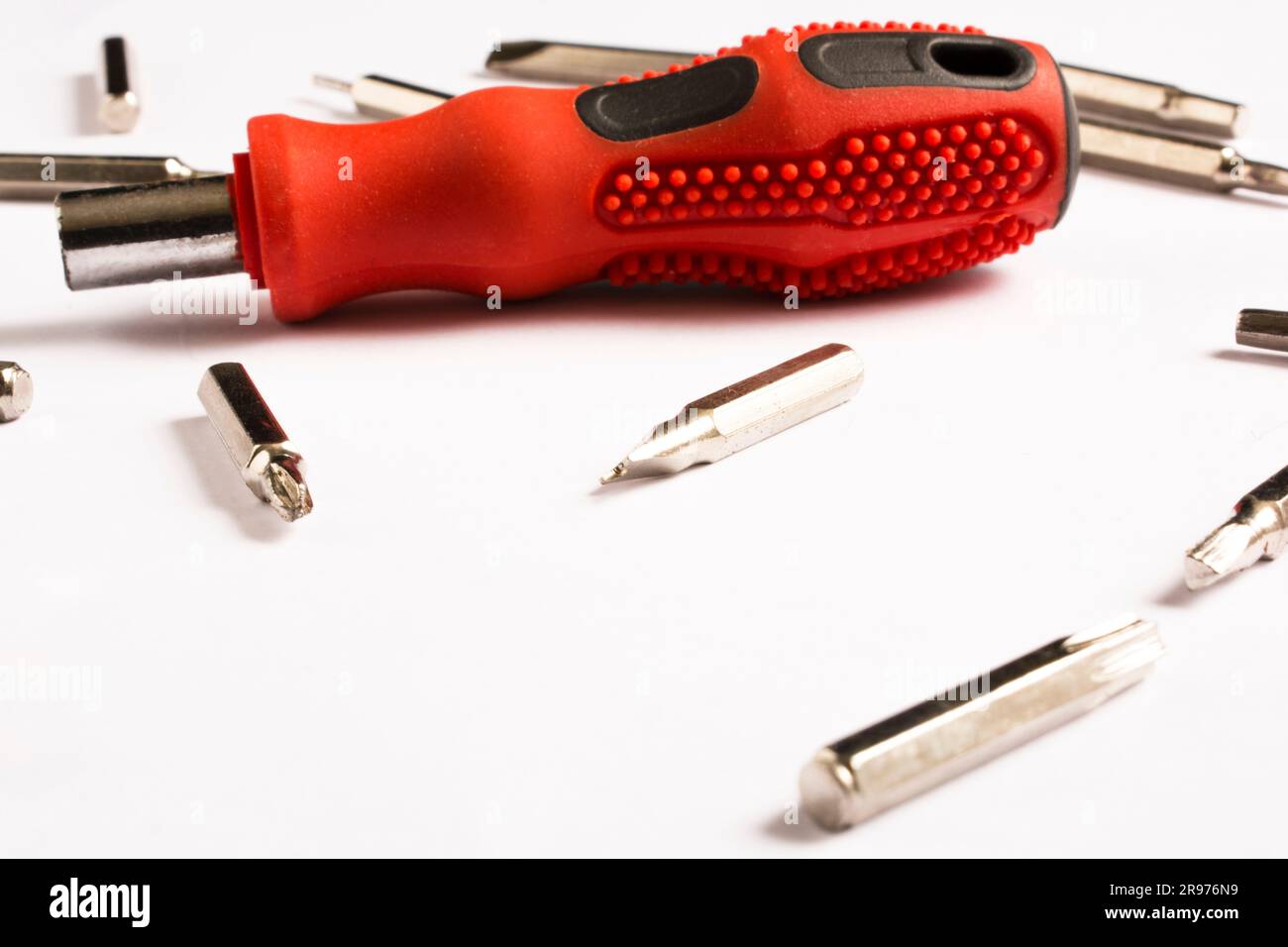 red screwdriver, white background and bits, spare parts Stock Photo - Alamy