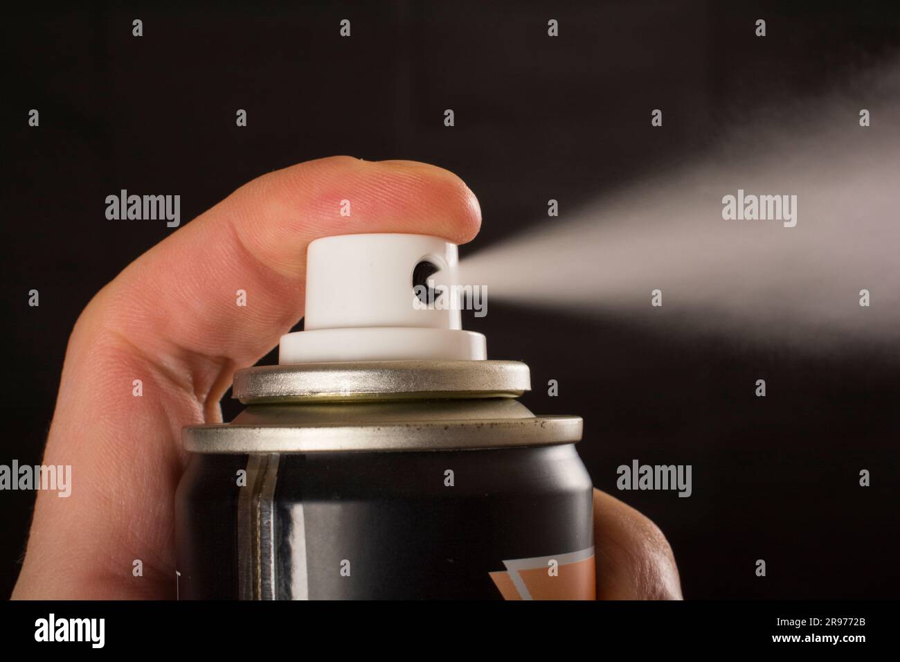 Close-up view of a human hand and pressed bottle of spray isolated on a ...