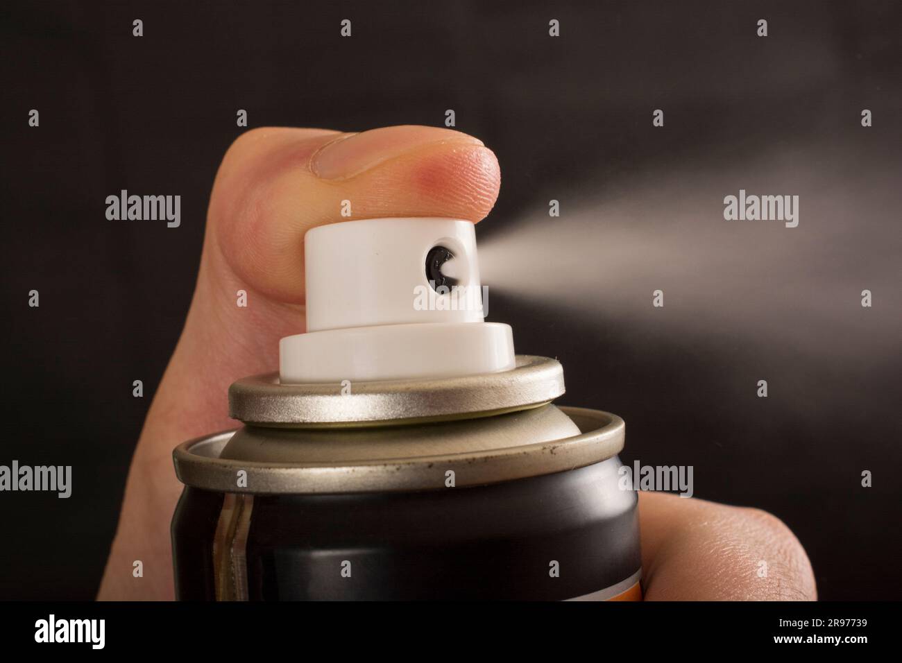 Close-up view of a human hand and pressed bottle of spray isolated on a ...