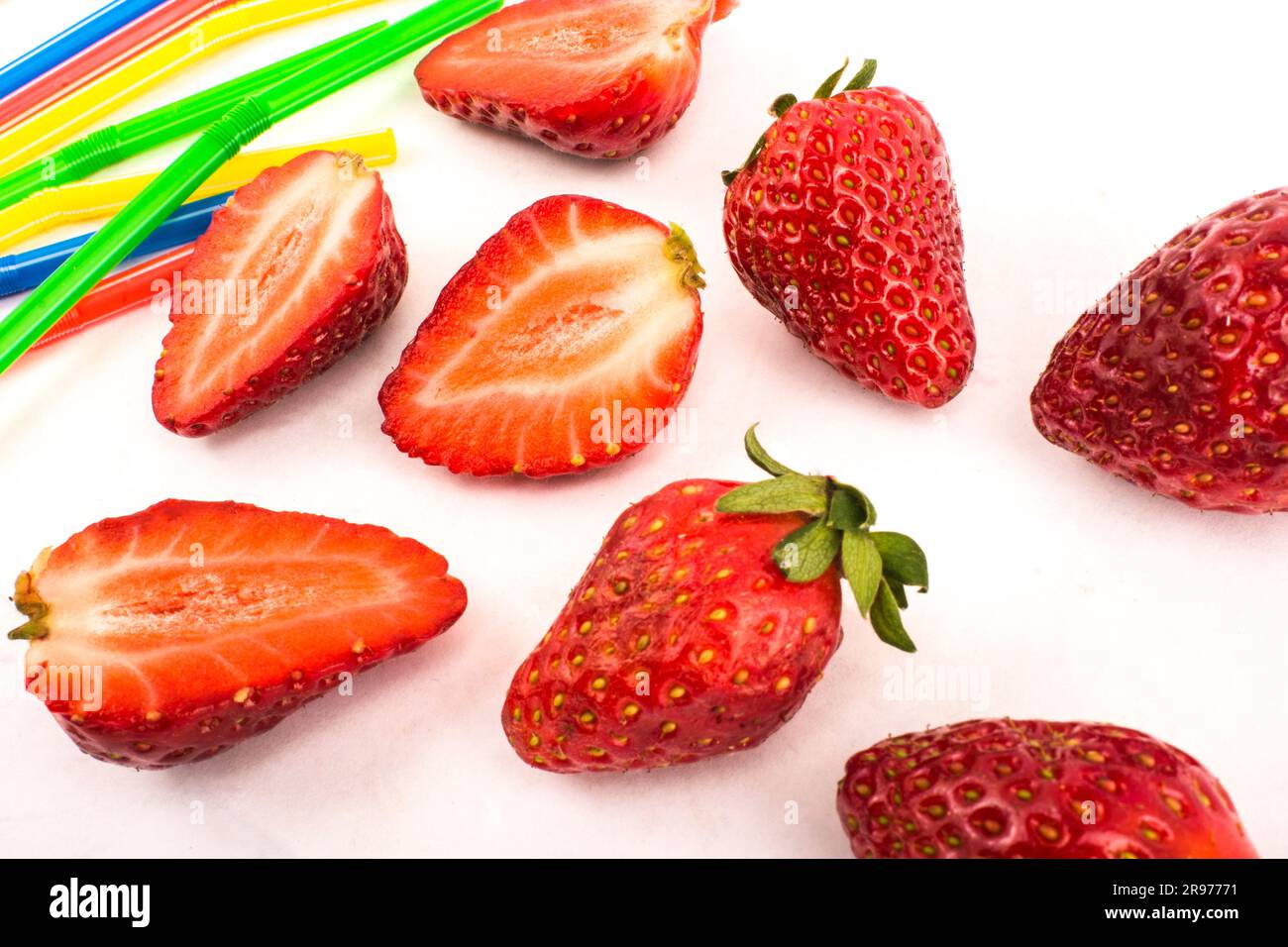 Strawberry and colored straws scattered on a white background Stock ...