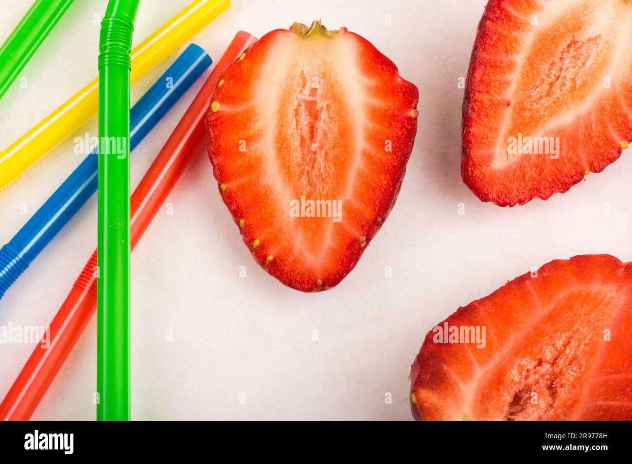 Strawberry and colored straws scattered on a white background Stock ...