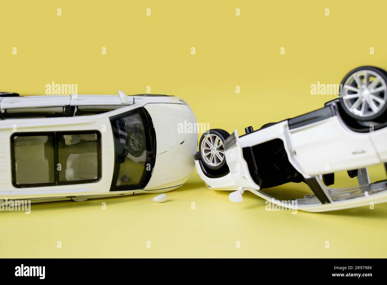 Two mini toy car crash on yellow background, incident, car traffic ...