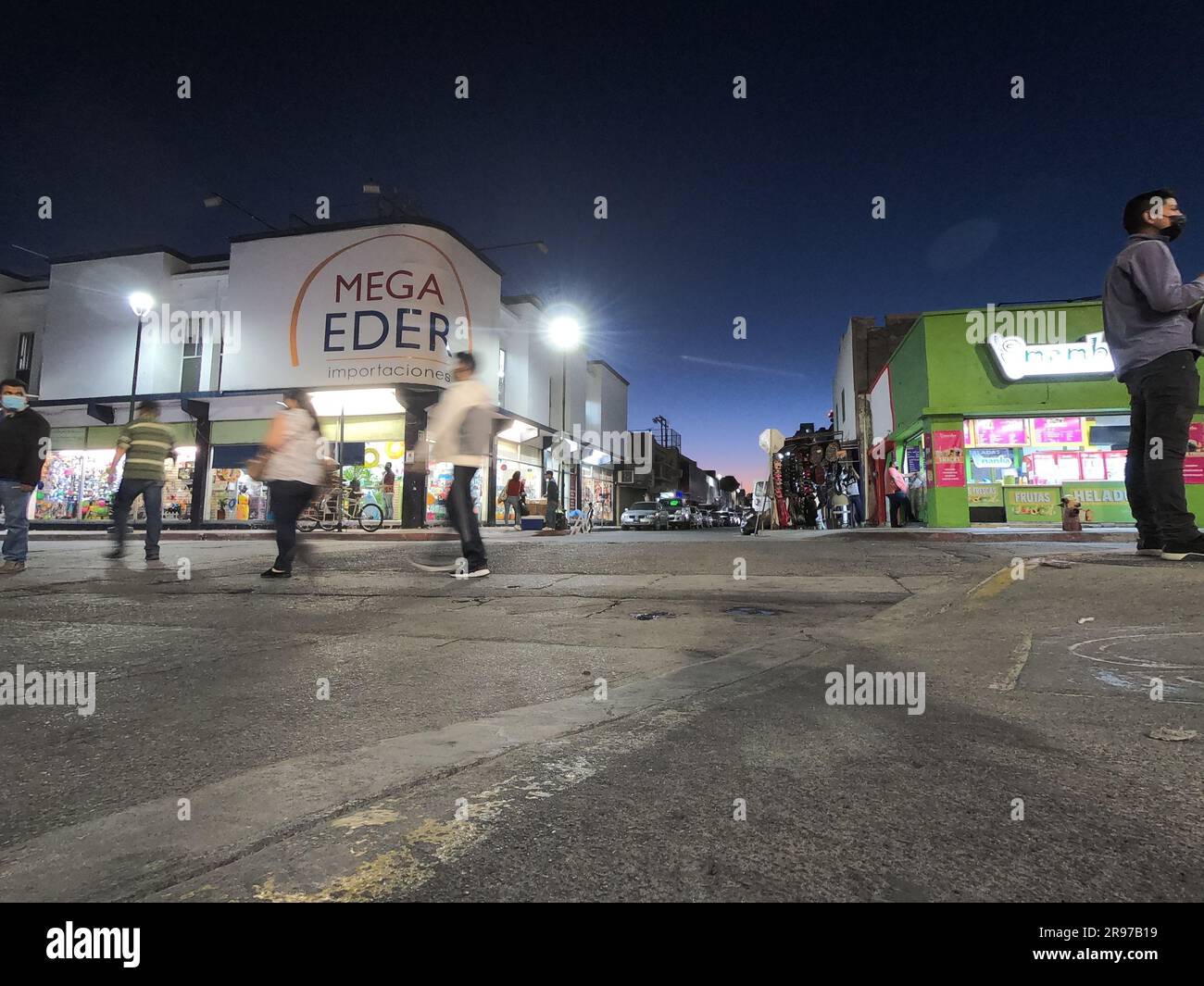 Daily life in the center of the city at dusk with people walking in ...