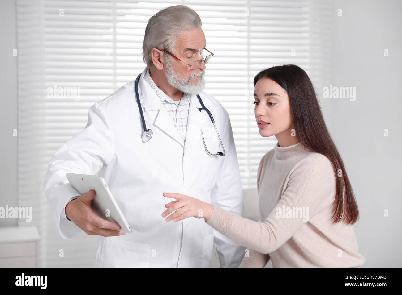 Patient having appointment with senior doctor in clinic Stock Photo - Alamy