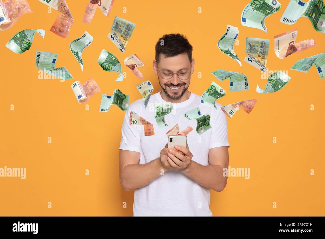 Online payment. Man buying something using mobile phone on orange ...