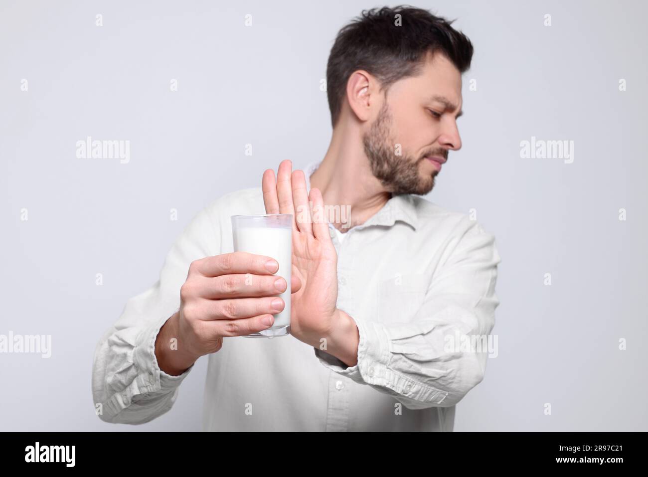 Man with glass of milk suffering from lactose intolerance on white ...