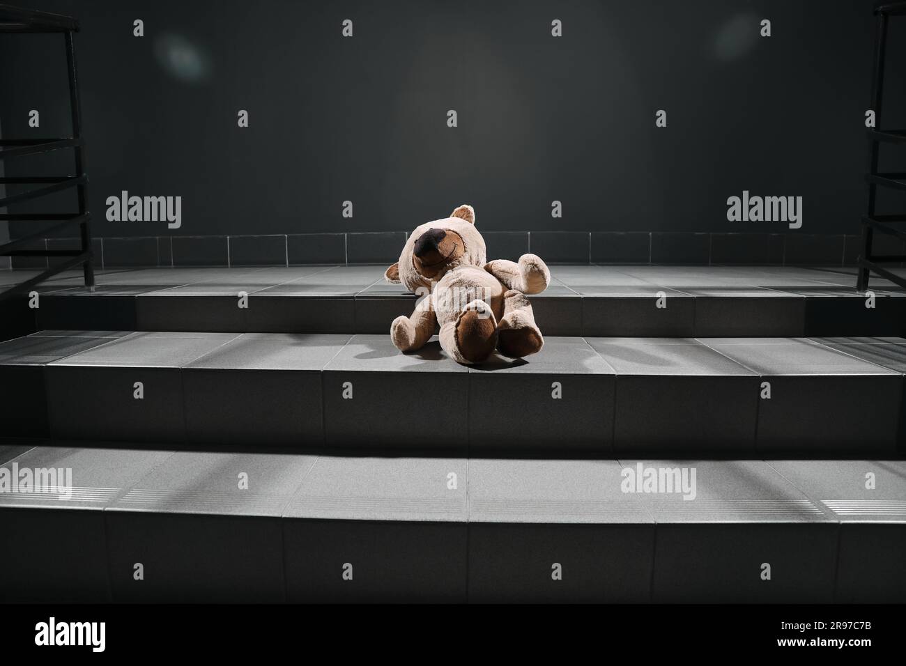 Lonely teddy bear on grey stairs indoors Stock Photo - Alamy