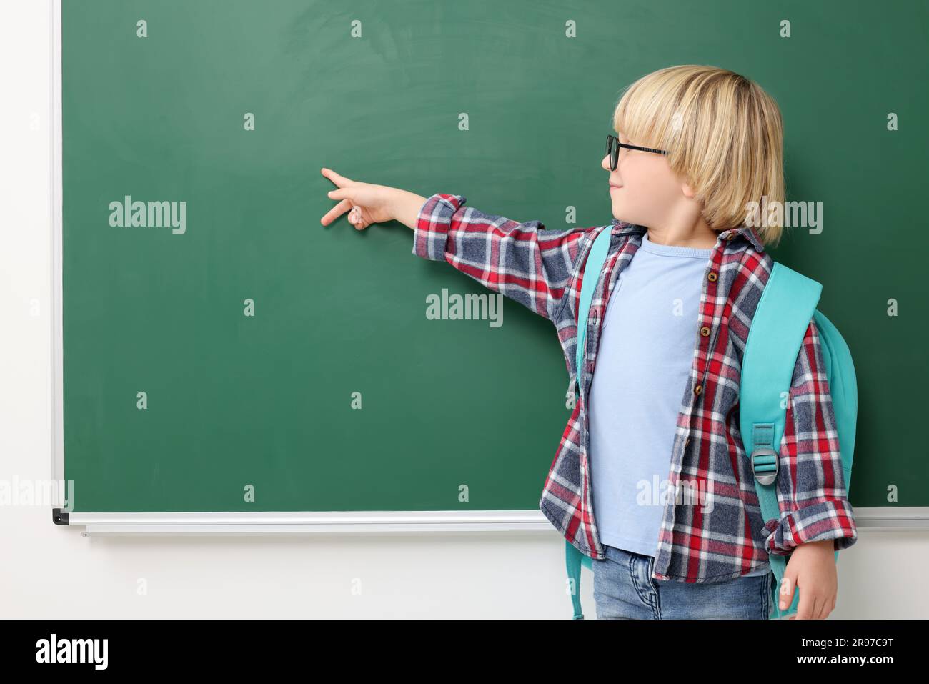 Little school child pointing at chalkboard. Space for text Stock Photo ...